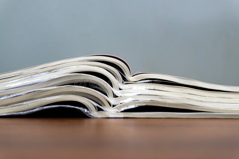 Open Magazines Lie on Top of Each Other on a Brown Table, Documents are ...