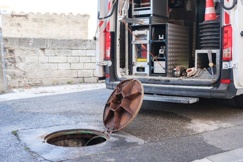 Open Manhole Cover and Workers with Repair Tools Stock Photo - Image of ...