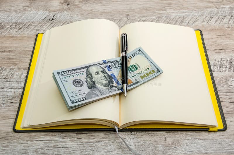 Open Notebook, Pen and Dollars on a Wooden Table Stock Image - Image of ...