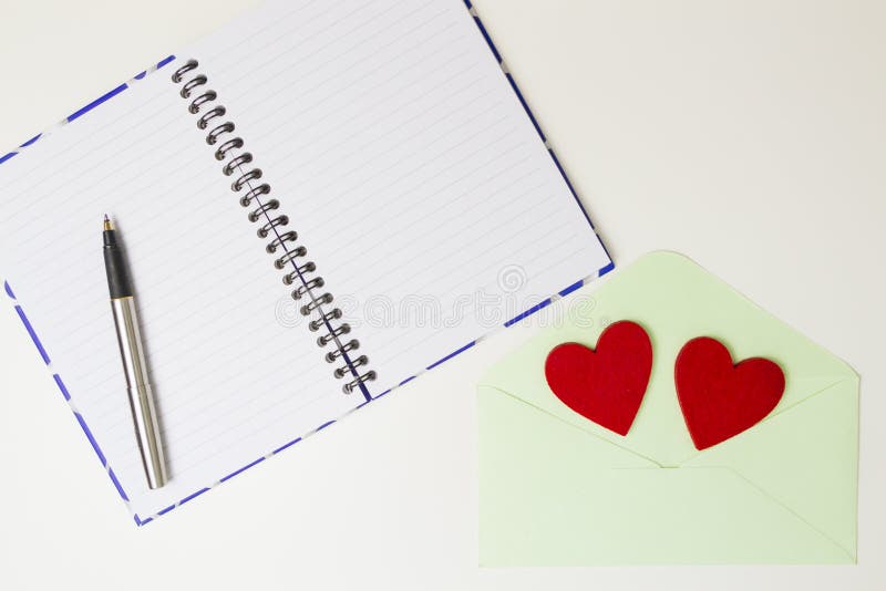 Open Notebook, Pen, Pastel Envelope and Two Red Felt Hearts on White ... Open Notebook, Pen, Pastel Envelope and Two Red Felt Hearts on White ...