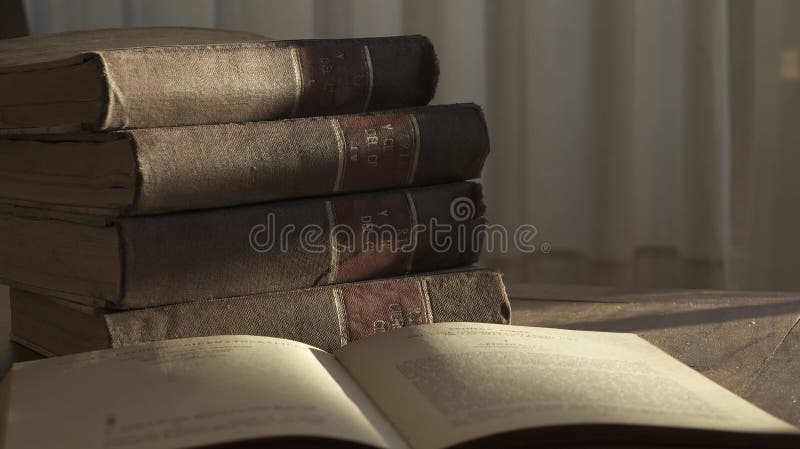 Open Old Book and Pile of Old Books on a Wooden Table on Sunrise Light ...