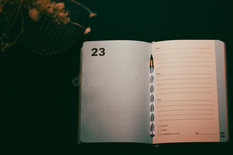 An Open Pad with a Date 23 is Lying on Dark Table Top View. a Notebook ...