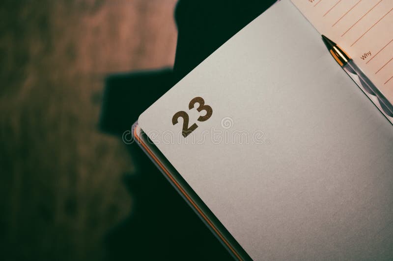 An Open Pad with a Date 23 is Lying on Dark Table Top View. a Notebook ...