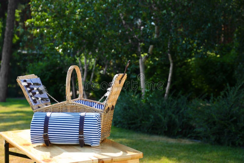 Open Picnic Basket with Blanket on Wooden Table in Green Park Stock ...