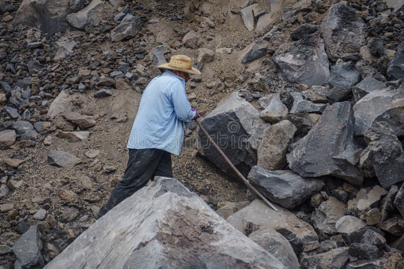 Man Using a Metal Bar To Pull the Volcanic Rock Stock Image - Image of ...