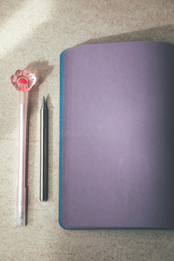 An Open Purple Notebook and Two Pens for Notes on a Light Table Stock ...