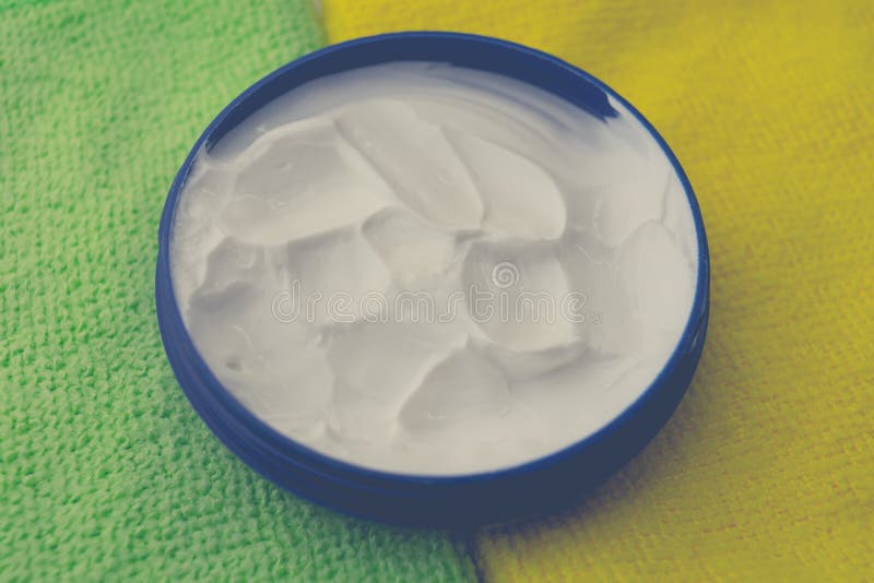 Open Round Container with White Cream on a Green Yellow Table Stock ...