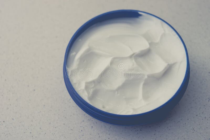 Open Round Container with White Cream on a Yellow Table Stock Photo ...