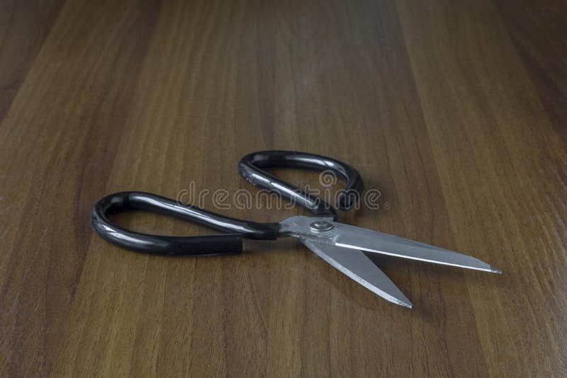 Open Scissors on a Yellow Wooden Table Surface Stock Image - Image of ...