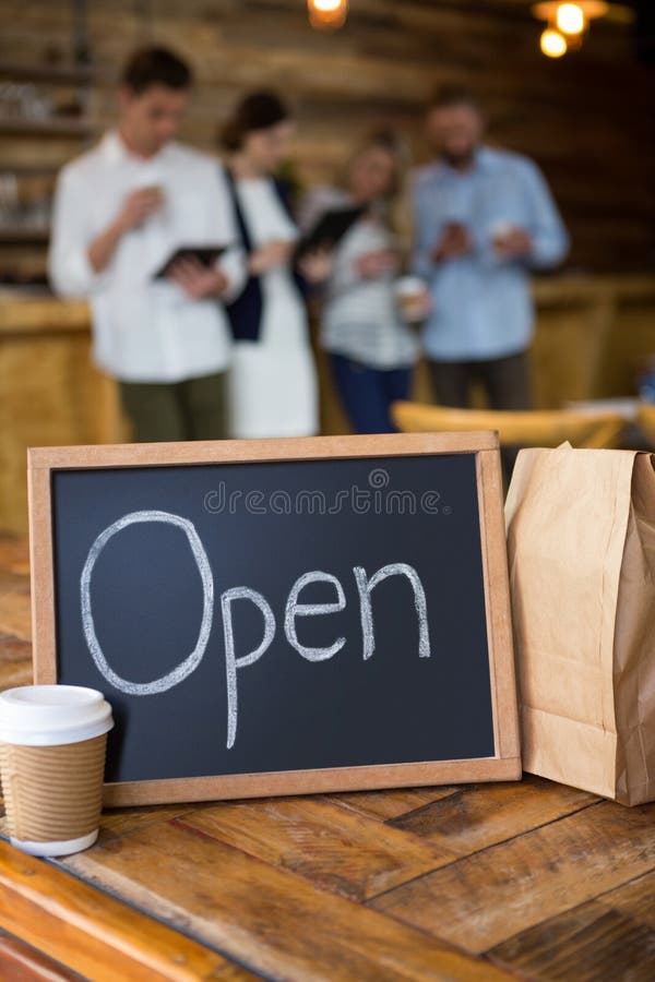Open Signboard with Disposable Coffee Cup and Paper Bag in Cafeteria ...