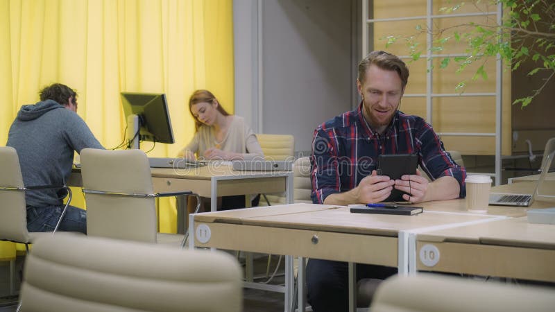 Open Space People Work, Man in Headphones Speaks with a Tablet. Stock ...