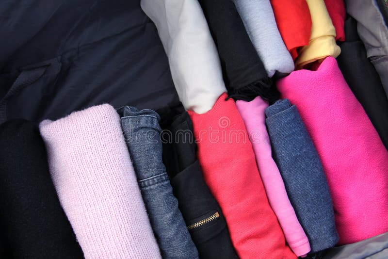 Open Suitcase on the Green Grass with Different Clothes Folded ...