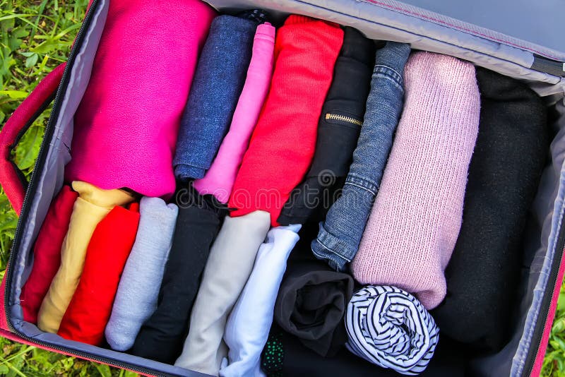 Open Suitcase on the Green Grass with Different Clothes Folded ...