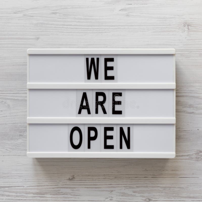 `we are Open` Text on a Lightbox on a White Wooden Surface, Top View ...