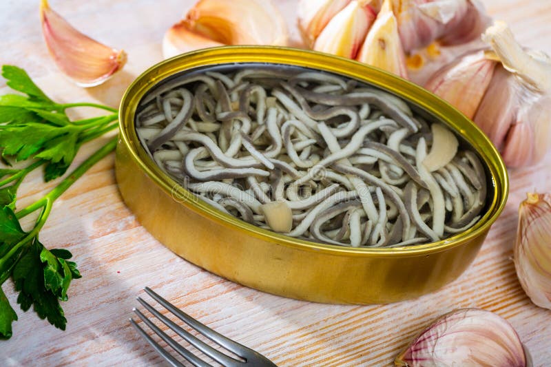 Open Tin Can of Pickled Eels and Garlic with Greens at Table Stock ...
