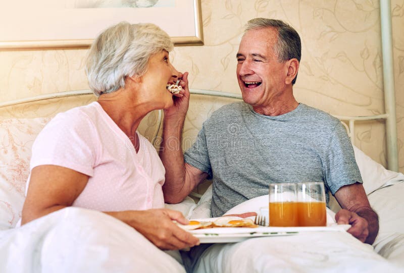 Open Wide. a Senior Couple Having Breakfast in Bed Together. Stock ...