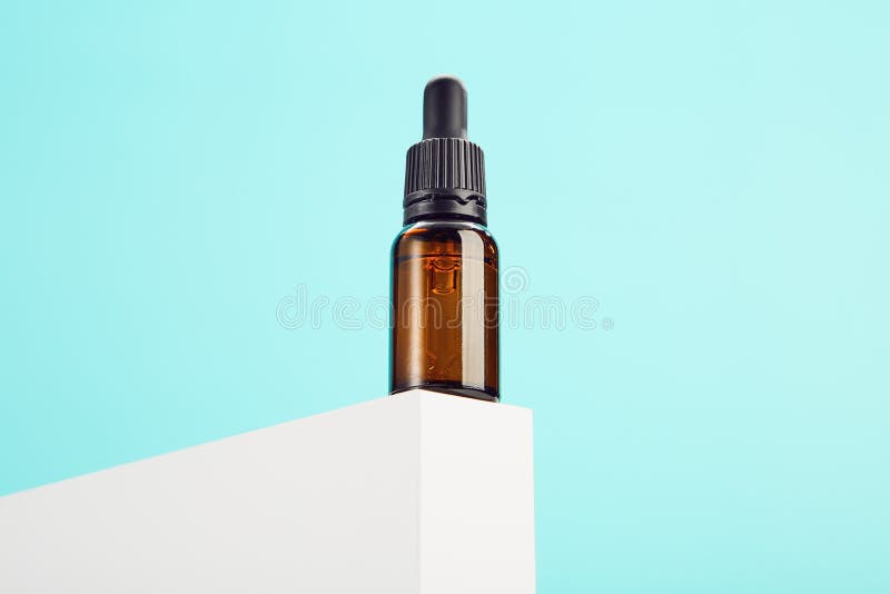 Opened Glass Dropper Container is on White Shape on Blue. Stock Photo ...