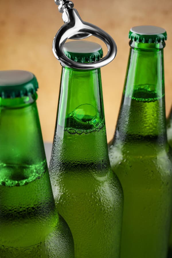 Opening Bottle of Beer on Light Brown Background, Closeup Stock Photo ...
