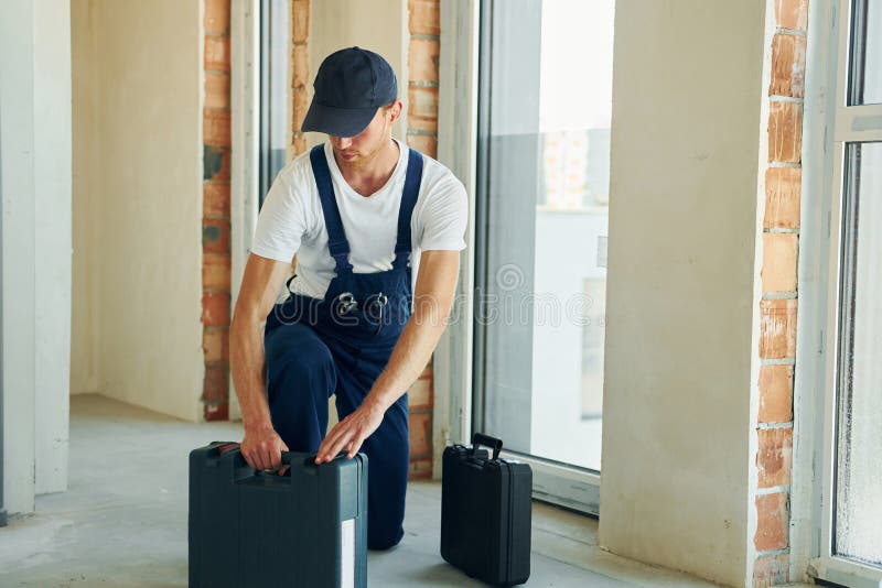 Opening the Case. Young Man Working in Uniform at Construction at ...