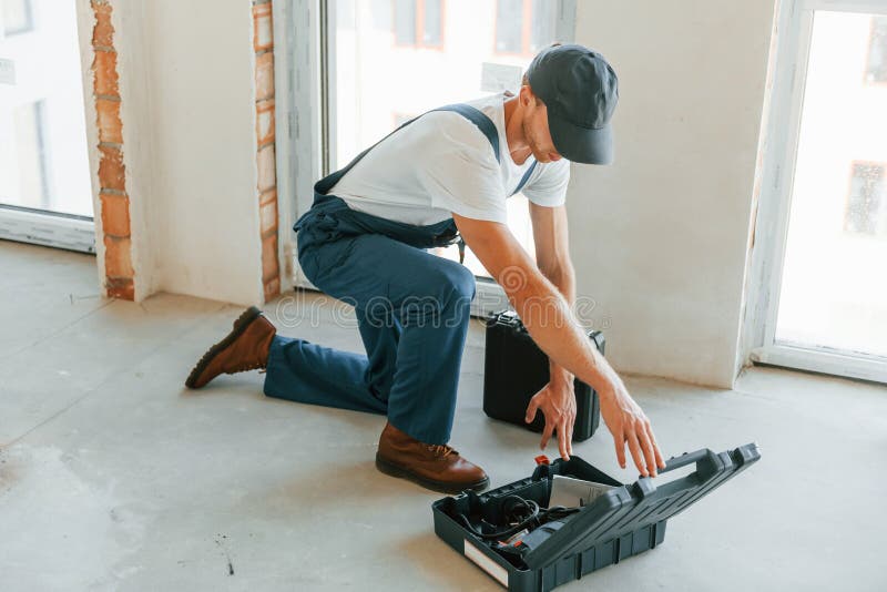 Opening the Case. Young Man Working in Uniform at Construction at ...