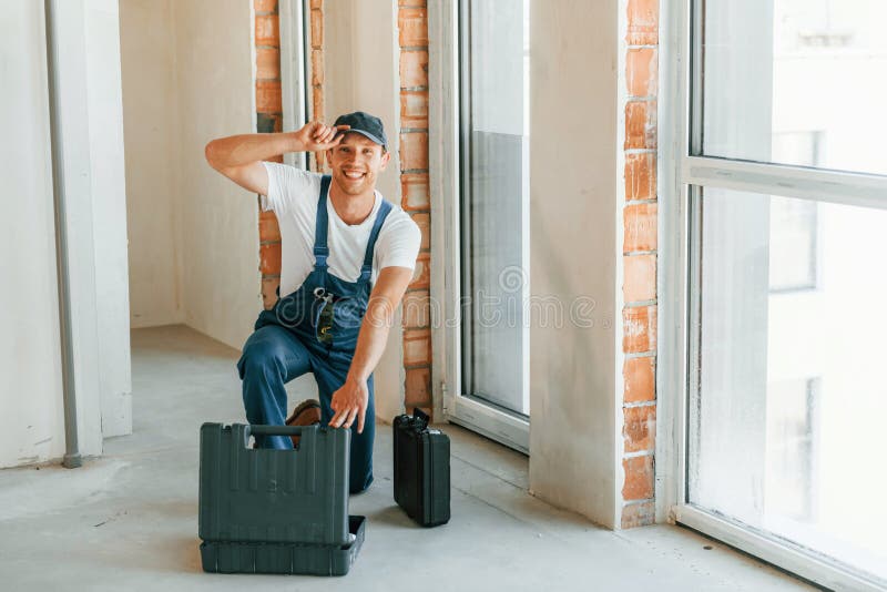 Opening the Case. Young Man Working in Uniform at Construction at ...