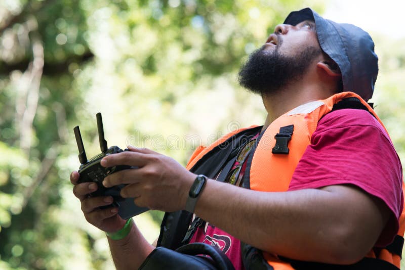 Operating Drone Flying Or Hovering By Remote Control By A Man In