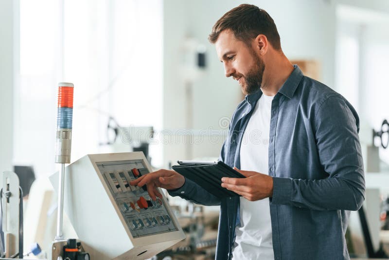 Operating the Machine. Handsome Man is Working at the Factory of ...