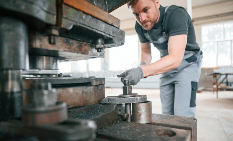 Operating Manufacturing Equipment. Man in Uniform is in Workstation ...
