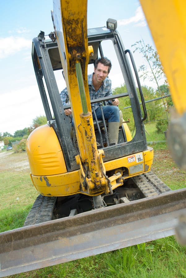 Operating a mini digger stock photo. Image of digger - 148281234
