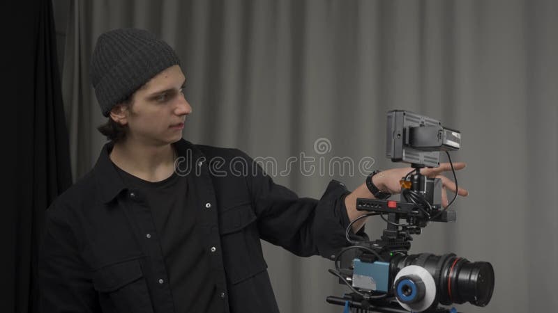 The Operator Adjusts a Professional Video Camera Standing on a Tripod ...