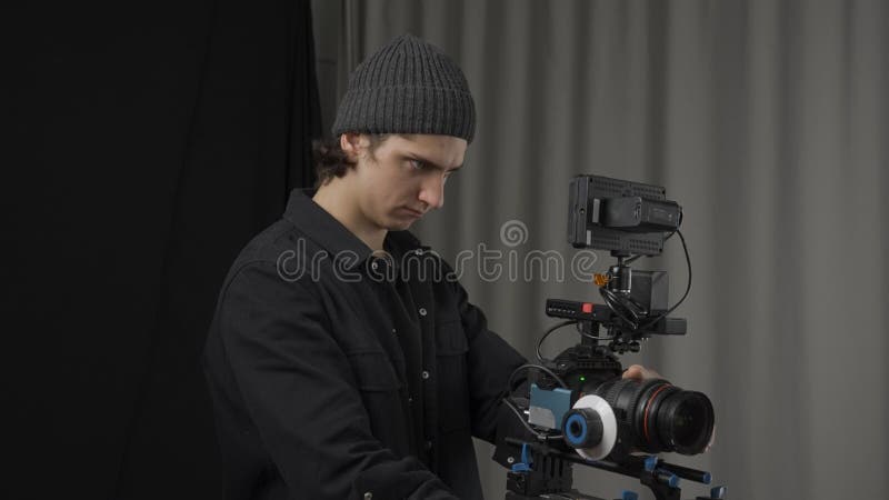 The Operator Adjusts a Professional Video Camera Standing on a Tripod ...