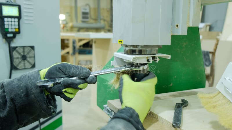 Operator of a Modern CNC Woodworking Machine Makes Adjustments before ...