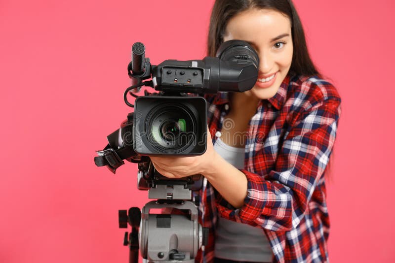 Operator with Professional Video Camera on Pink Background Stock Photo ...