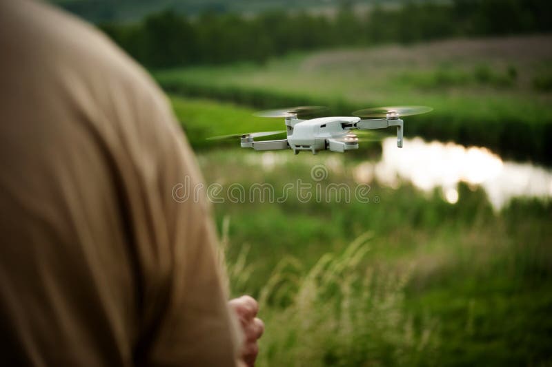 Operator Remote Mini Drone in the Air at Sunrise, Explores Floodplain ...