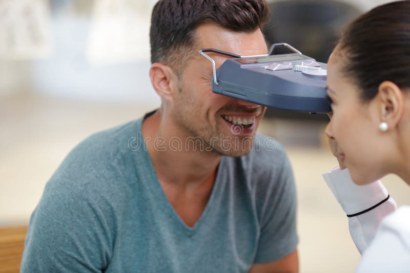 Ophthalmologist Using Handheld Device To Inspect Patients Eyes Stock ...