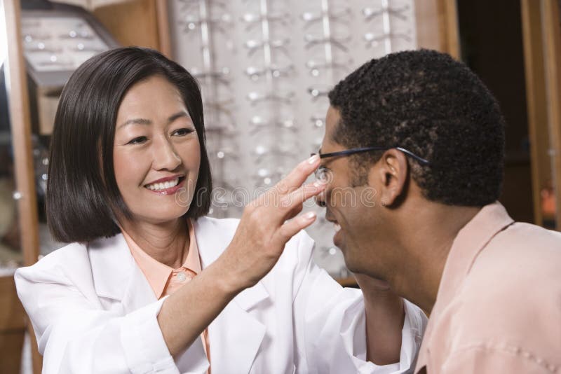 Optician Assisting Male Patient Stock Photo - Image of occupation ...
