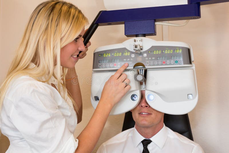 Optician or Optometrist and Patient with a Phoropter Stock Photo ...