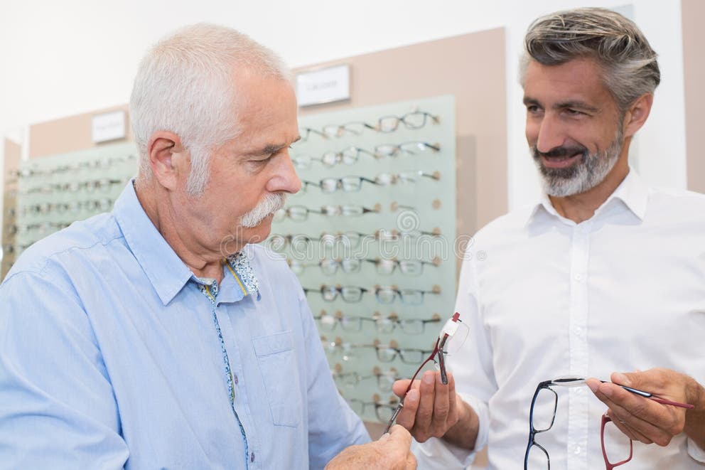 Optician Proposing Spectacles To Senior Customer Stock Photo - Image of ...