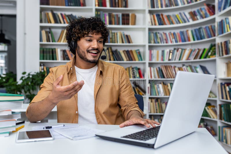 Optimistic Indian Student Using Wireless Headset and Laptop while ...