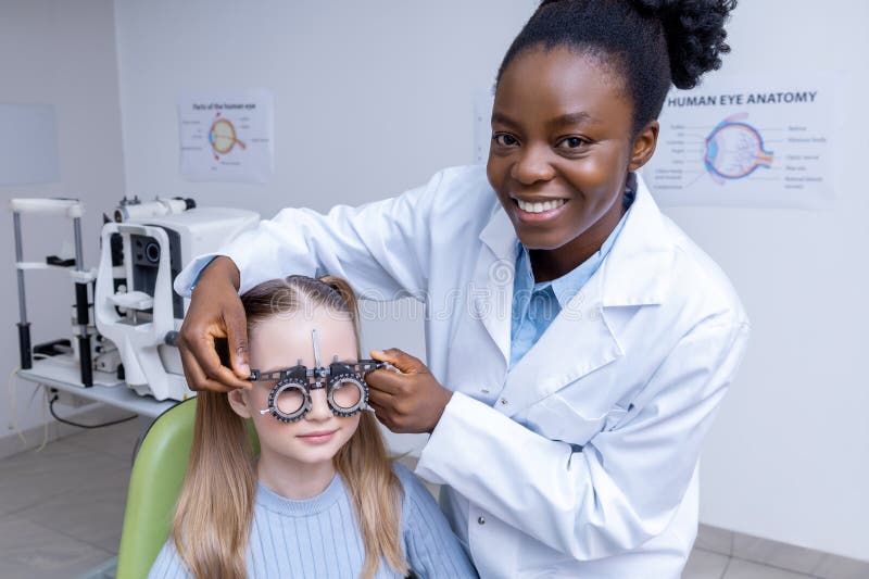 African American Female Optometrist Checking Vision of a Small Patient ...