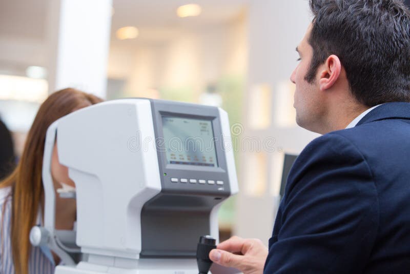 Optometrist in Exam Room with Woman in Chair Stock Photo - Image of ...