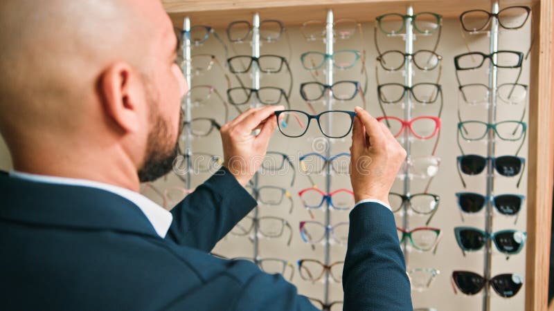 Optometrist Displaying Eyewear Selection in a Modern Spectacle Store ...