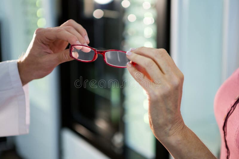 Optometrist Giving Spectacles To Customer in Optical Store Stock Image ...