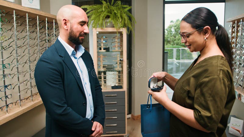 Customer Receiving Glasses from Professional Optometrist in Office ...