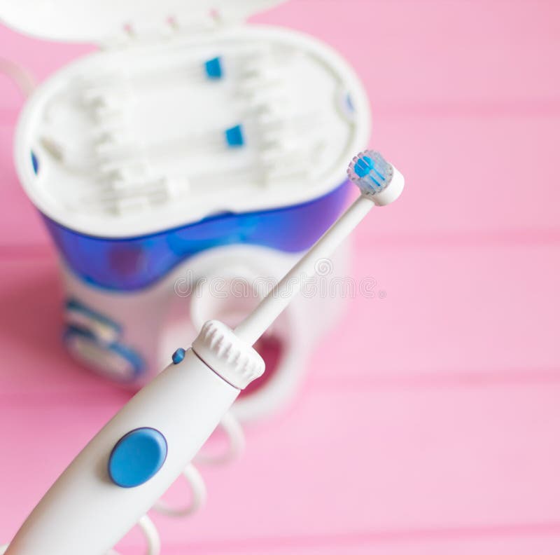Oral Hygiene. Irrigator for Cleaning Teeth on a Pink Background Stock ...