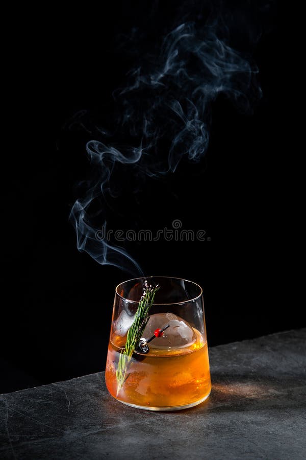 Orange Alcoholic Cocktail with a Sprig of Pine Needles and Round Ice ...