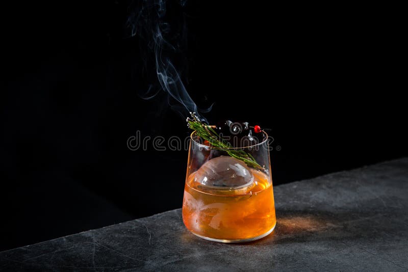 Orange Alcoholic Cocktail with a Sprig of Pine Needles and Round Ice ...