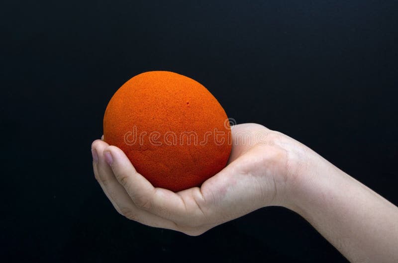 Orange ball in hand stock photo. Image of boxing, filled - 216051080