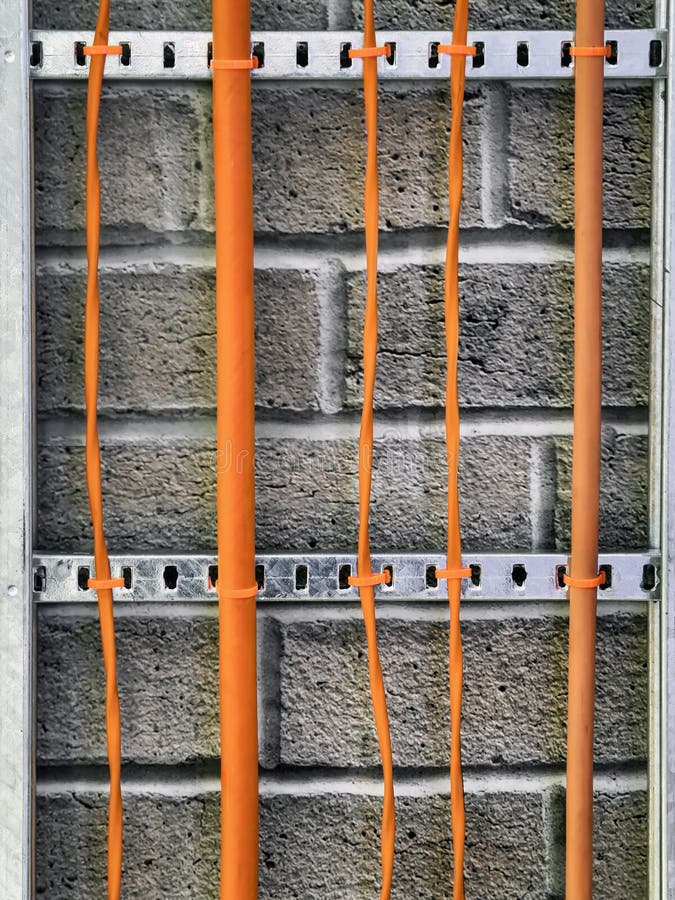 Orange Cables Run Along a Gray Brick Wall, Showcasing a Modern ...