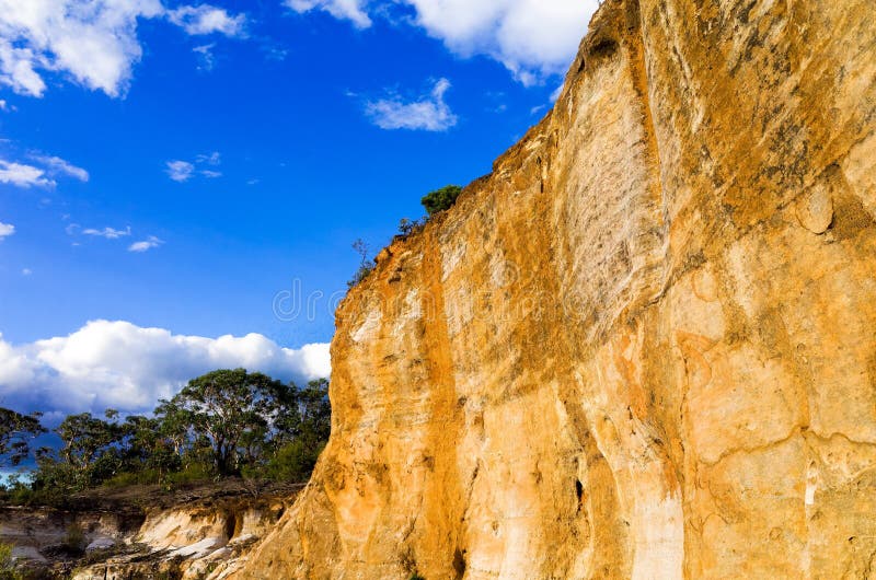 Orange Cliff Against Blue Cloudy Sky Stock Image - Image of bush, wales ...